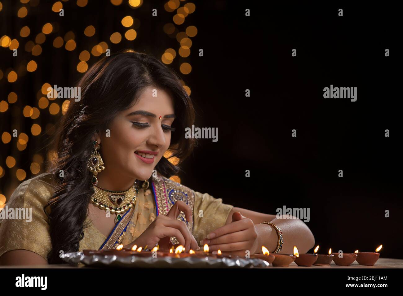 woman in saree lighting diya Stock Photo - Alamy