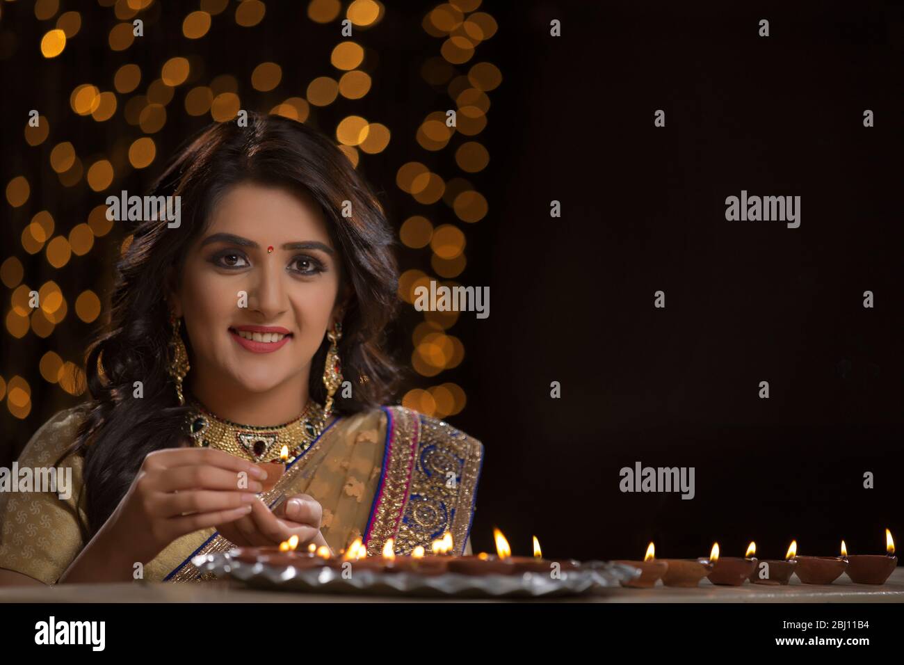 woman in saree lighting diya Stock Photo - Alamy
