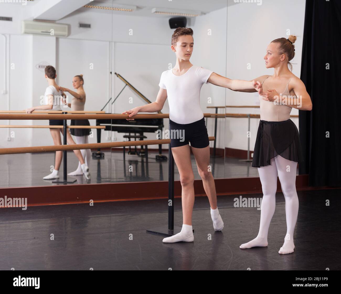 Choreographer helping young man dancer to have right position ...