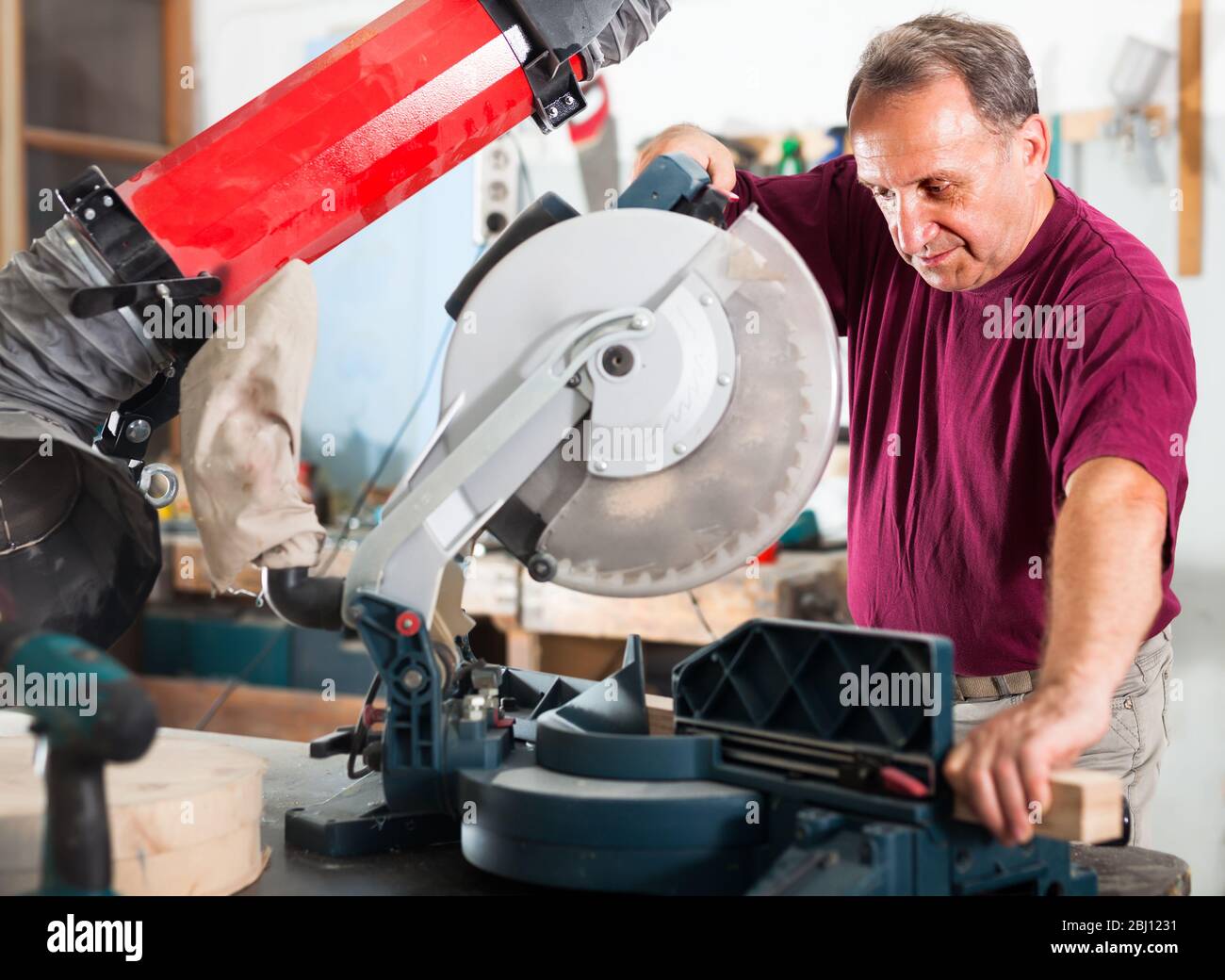 Confident workman cutting wooden planks using circular saw Stock Photo ...