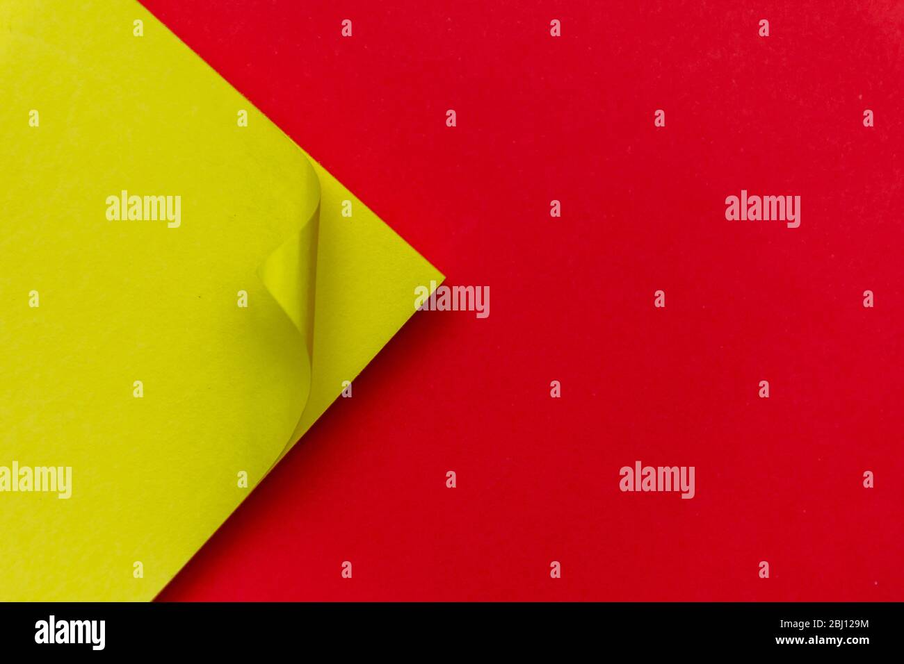 Bright yellow posted note on bright red flat lay background for ...