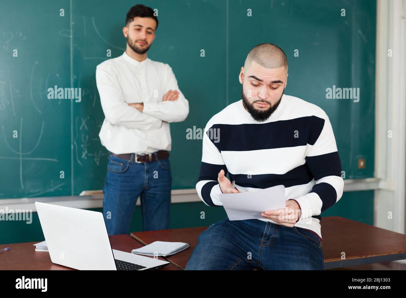 Portrait of two young guys working on their student project near ...