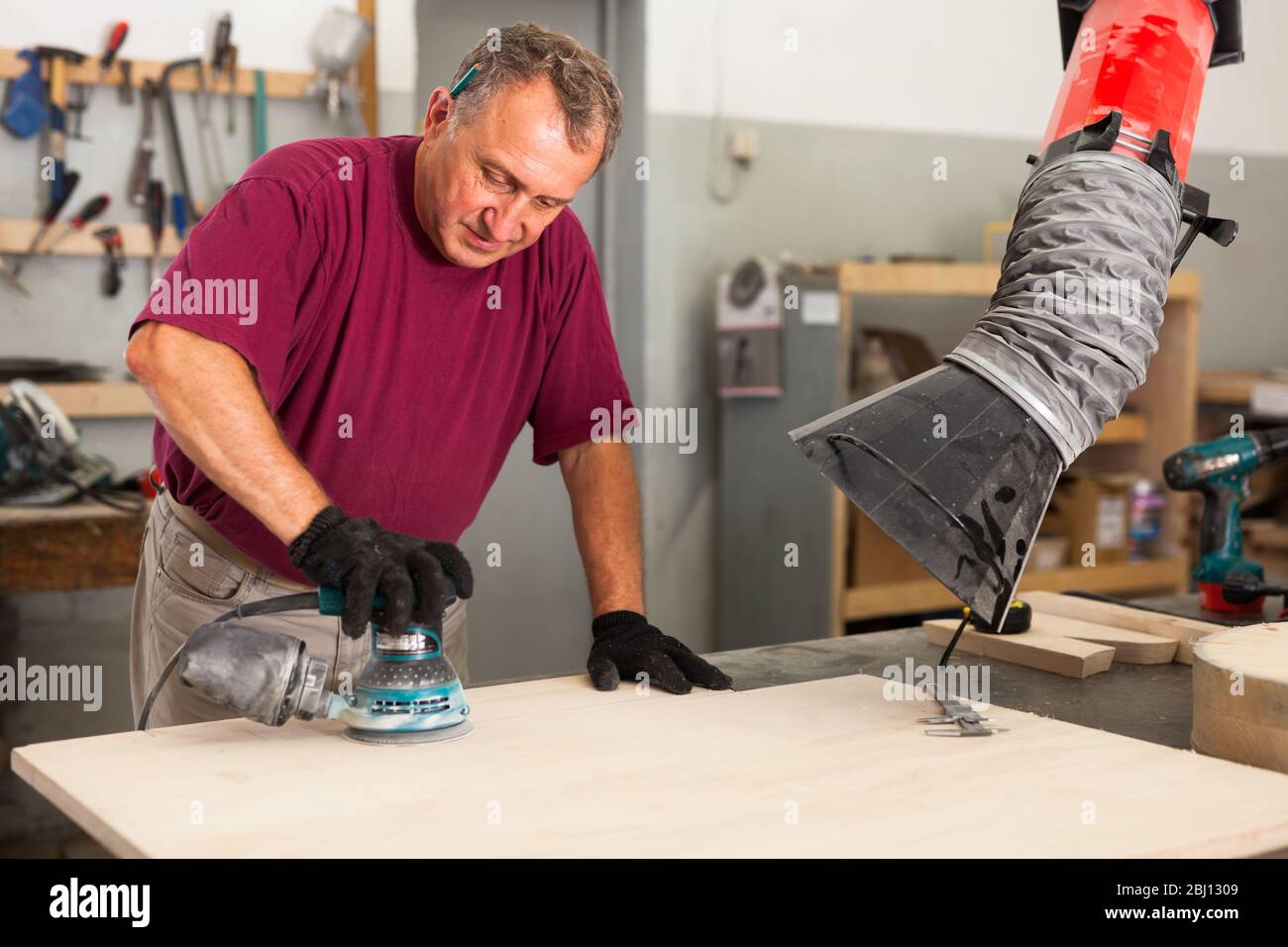 Worker grinds the wood plank of angular grinding machine Stock Photo ...