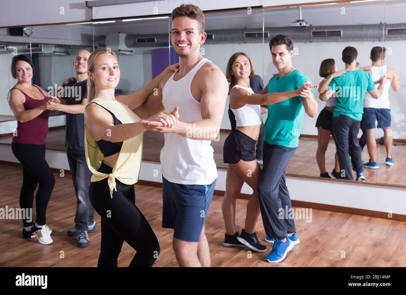 Group of positive adults dancing salsa together in dance class Stock ...