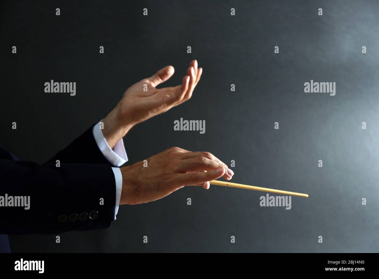 Music conductor hands with baton on black background Stock Photo - Alamy