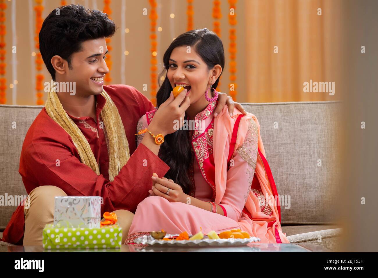brother stuffing sweets in sister's mouth Stock Photo - Alamy