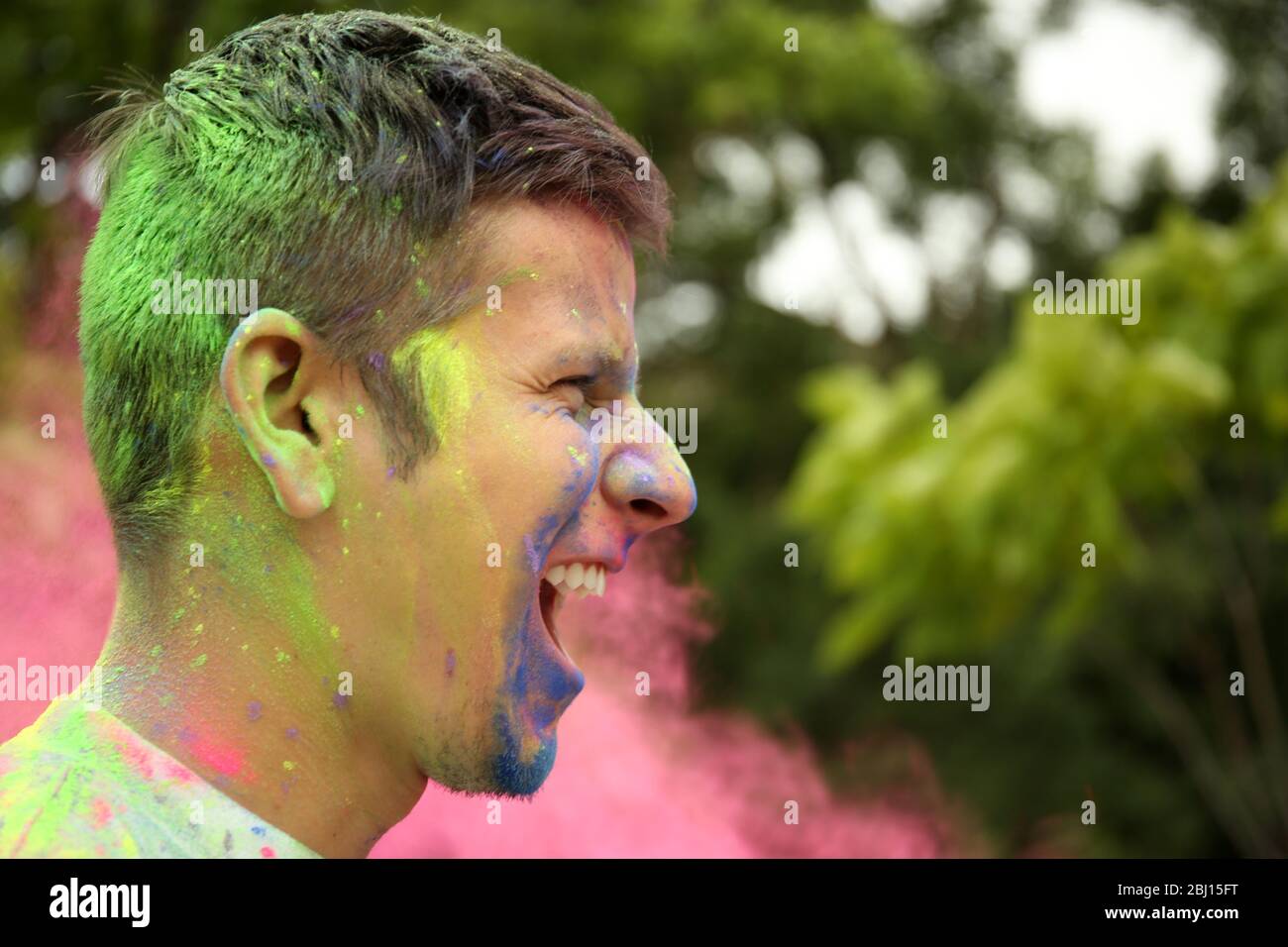 Young man on Holi color festival in park Stock Photo - Alamy