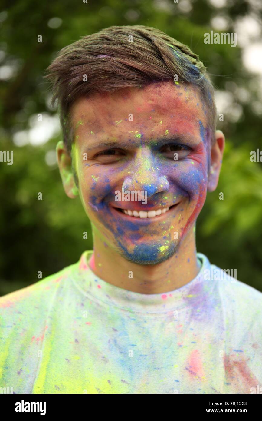 Young man on Holi color festival in park Stock Photo - Alamy