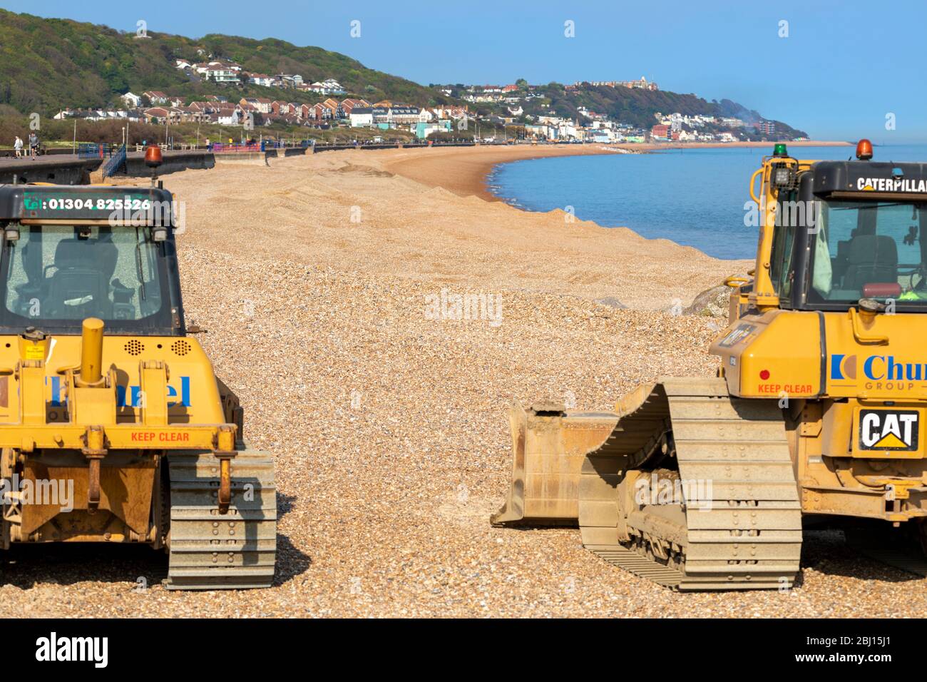 Two bulldozers working on a shingle beach for sea defenses Stock Photo ...