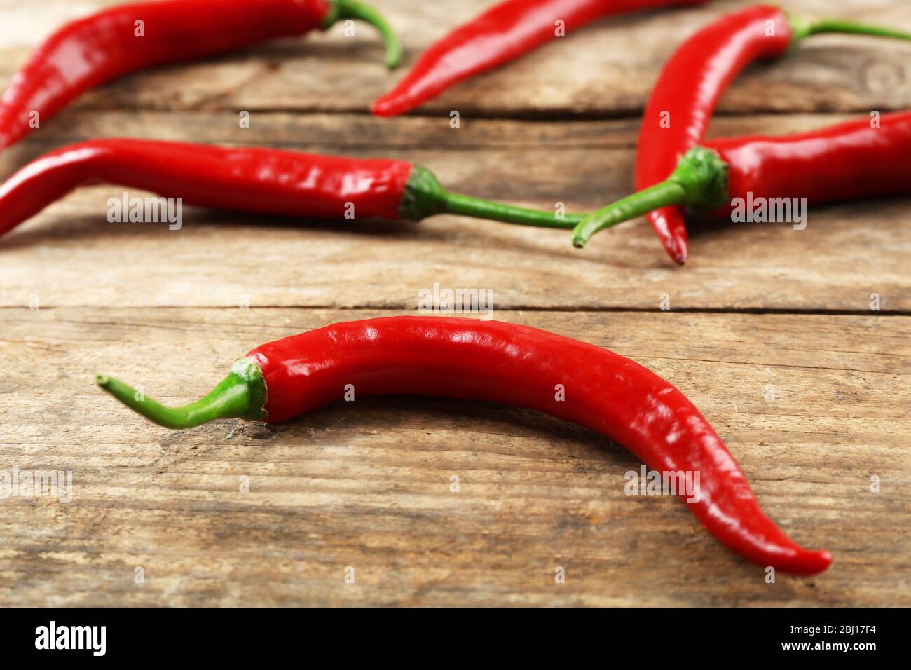 Red hot peppers on wooden table close up Stock Photo - Alamy