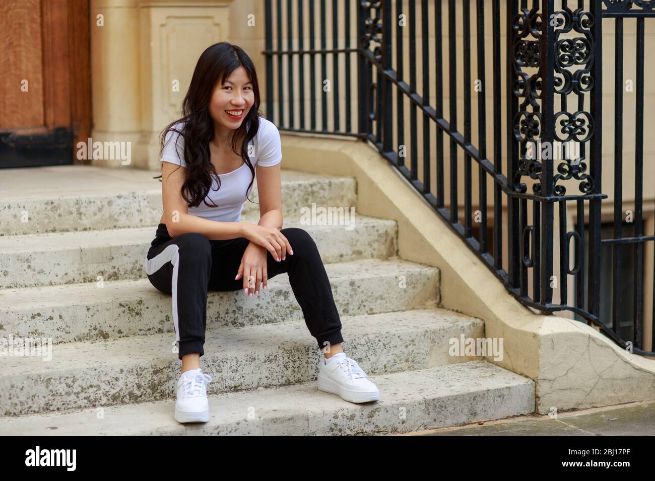 a young chinese lady sitting on steps in the street Stock Photo - Alamy