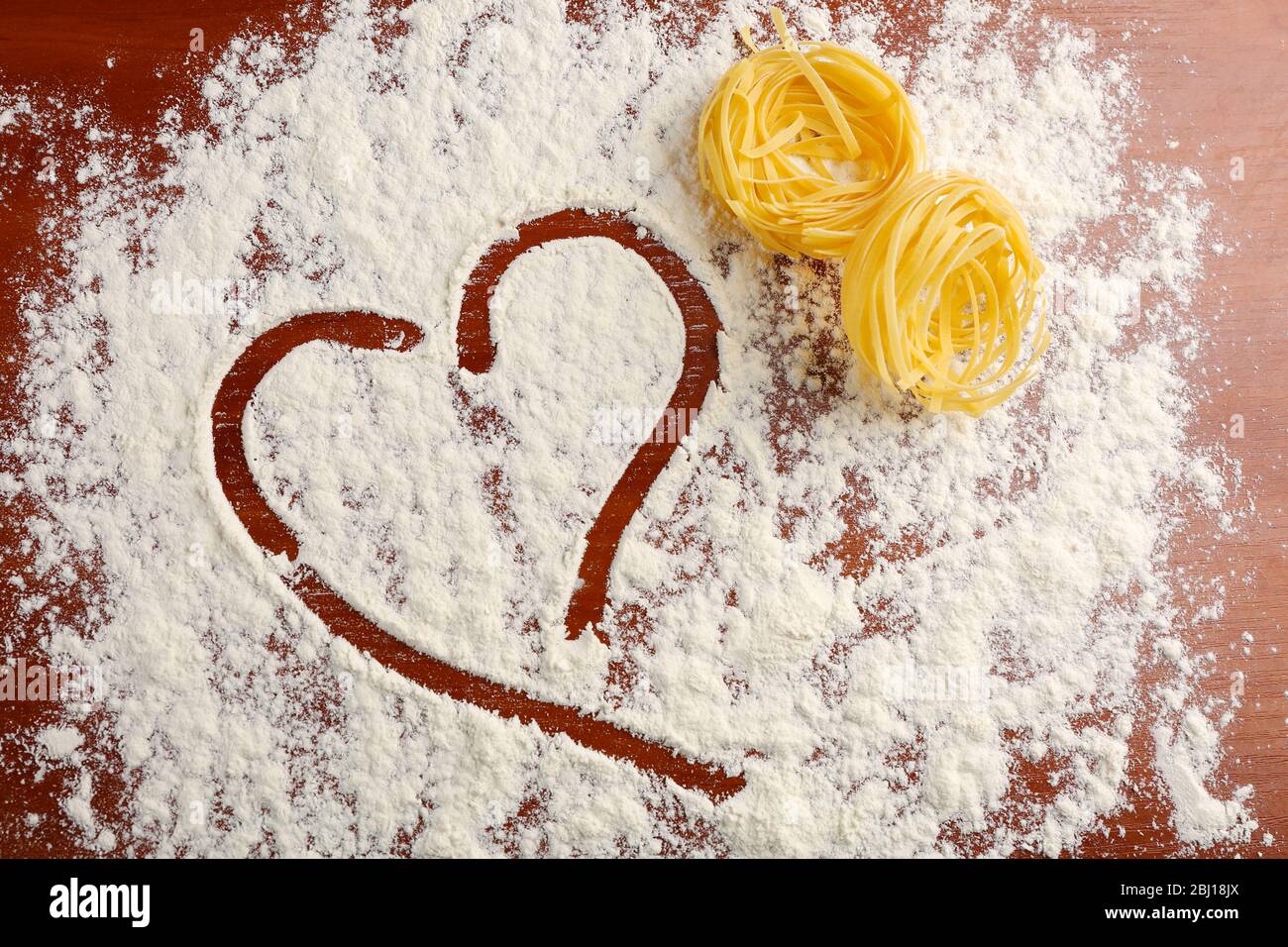 Row pasta on flour background Stock Photo - Alamy