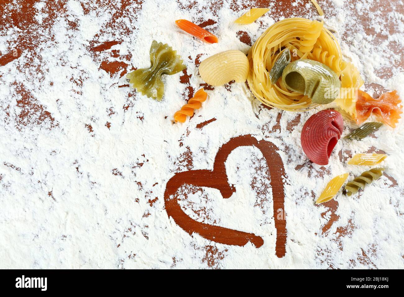 Row pasta on flour background Stock Photo - Alamy