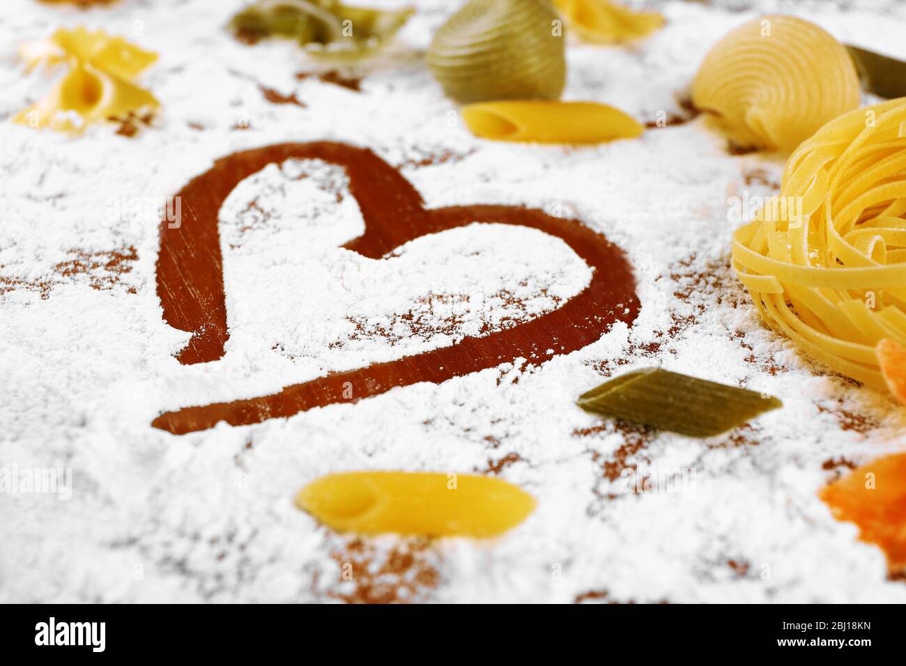 Row pasta on flour background Stock Photo - Alamy