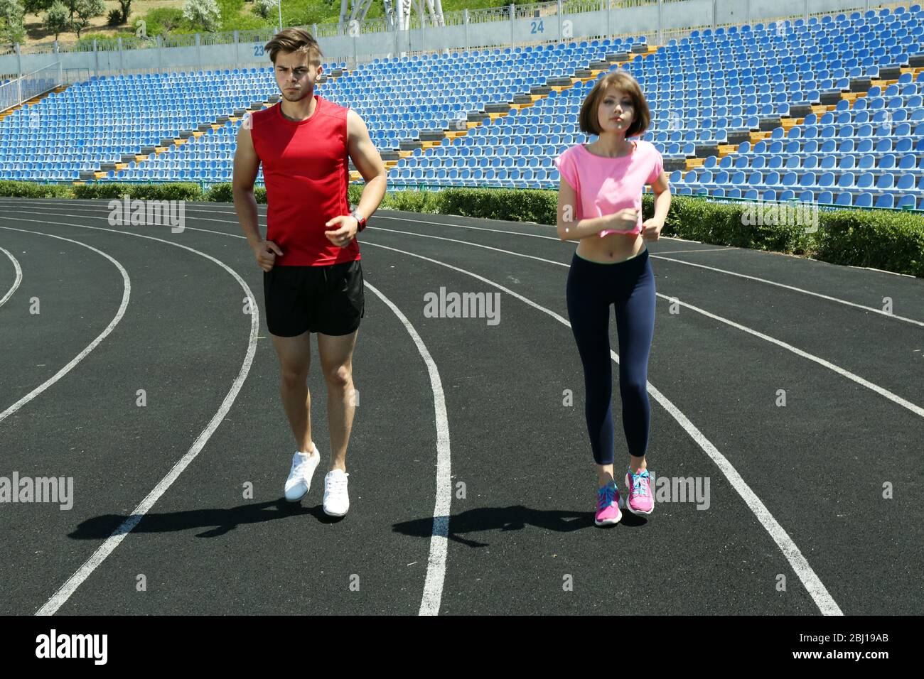 Young people jogging on stadium Stock Photo - Alamy