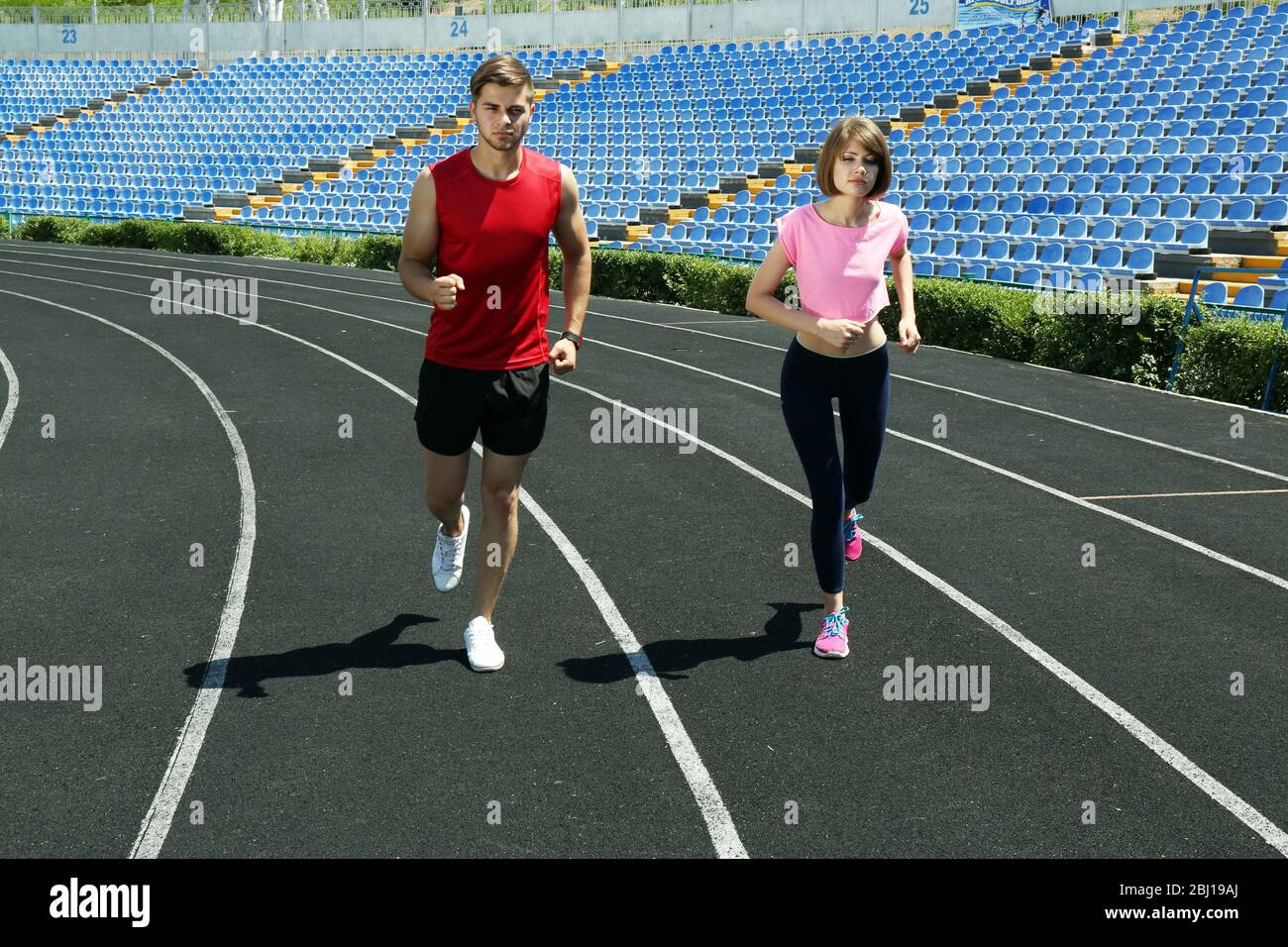 Young people jogging on stadium Stock Photo - Alamy