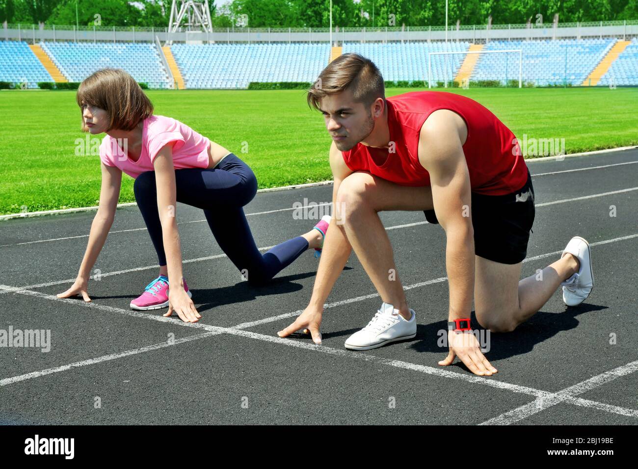 Runners in start position on stadium Stock Photo - Alamy