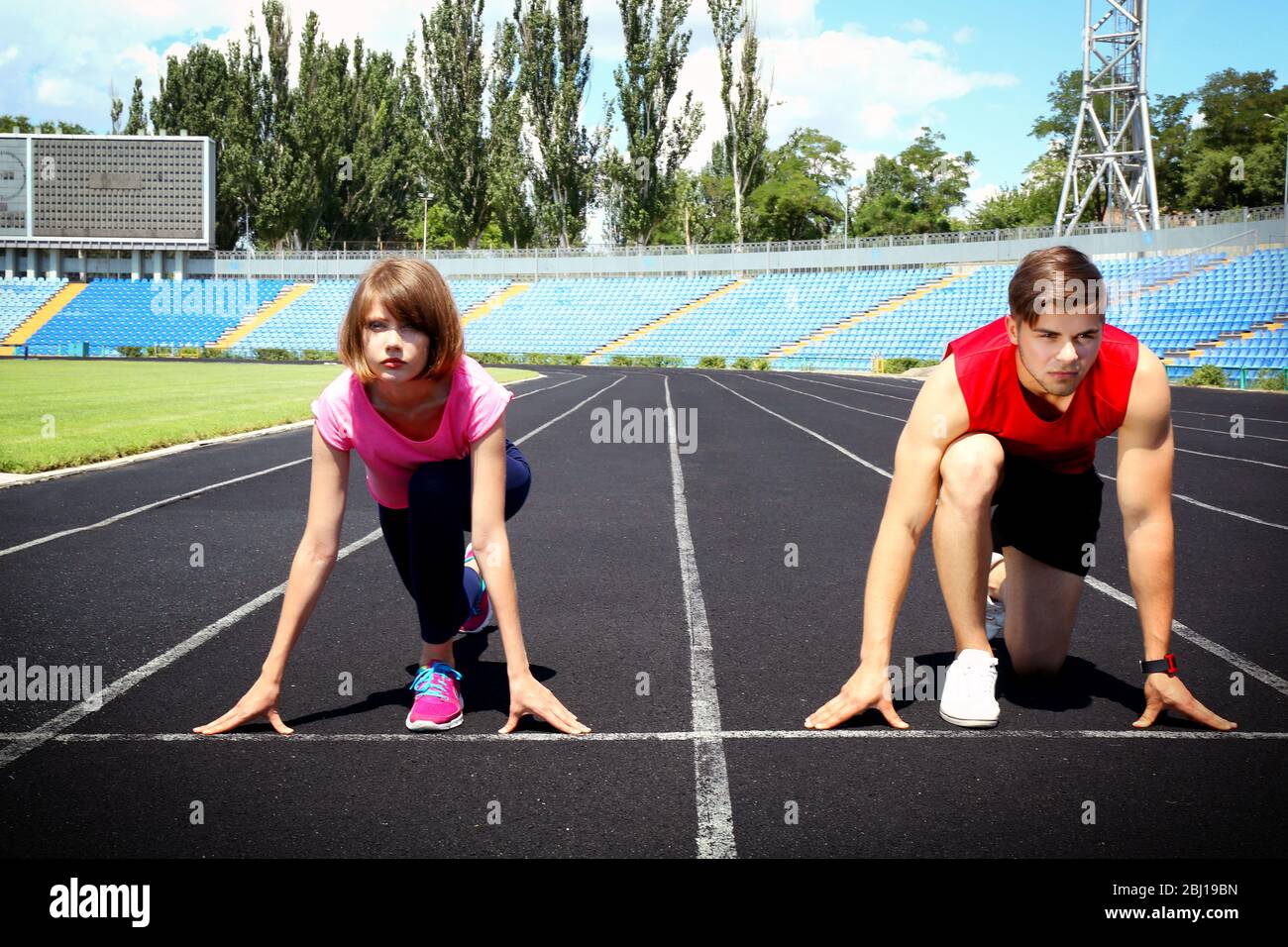 Runners in start position on stadium Stock Photo - Alamy