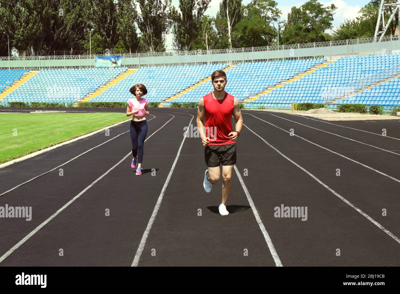 Young people jogging on stadium Stock Photo - Alamy