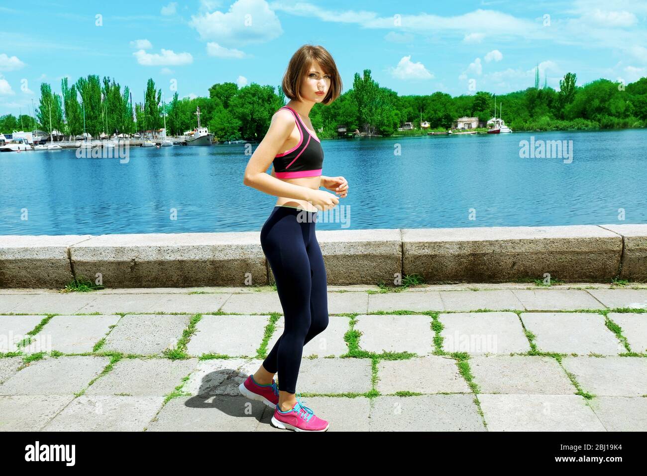 Young woman jogging near river Stock Photo - Alamy