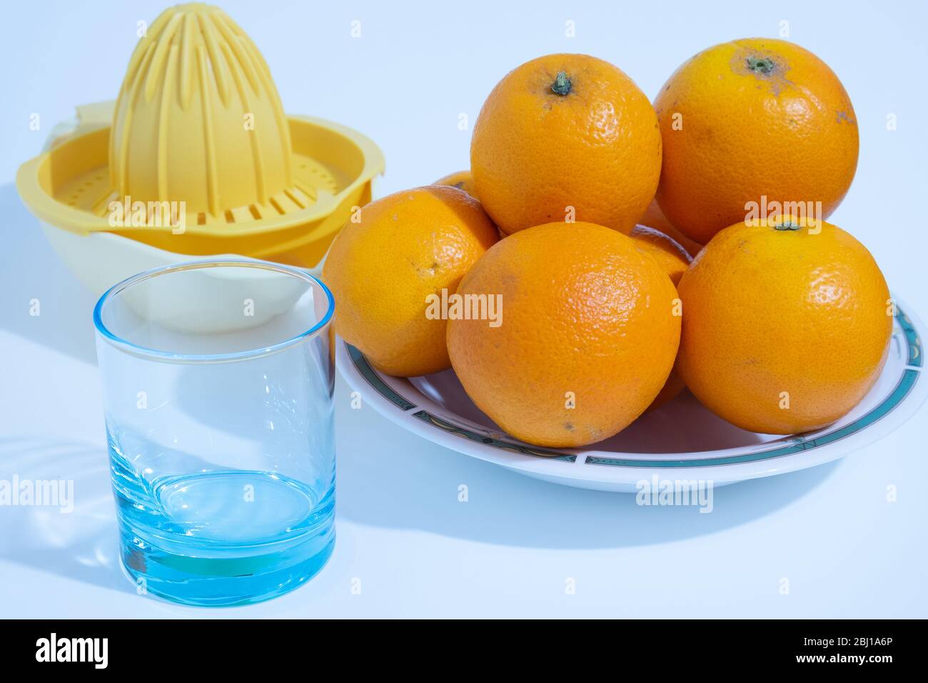 An empty glass with a juicer on the side and a plate full of vitamin C ...