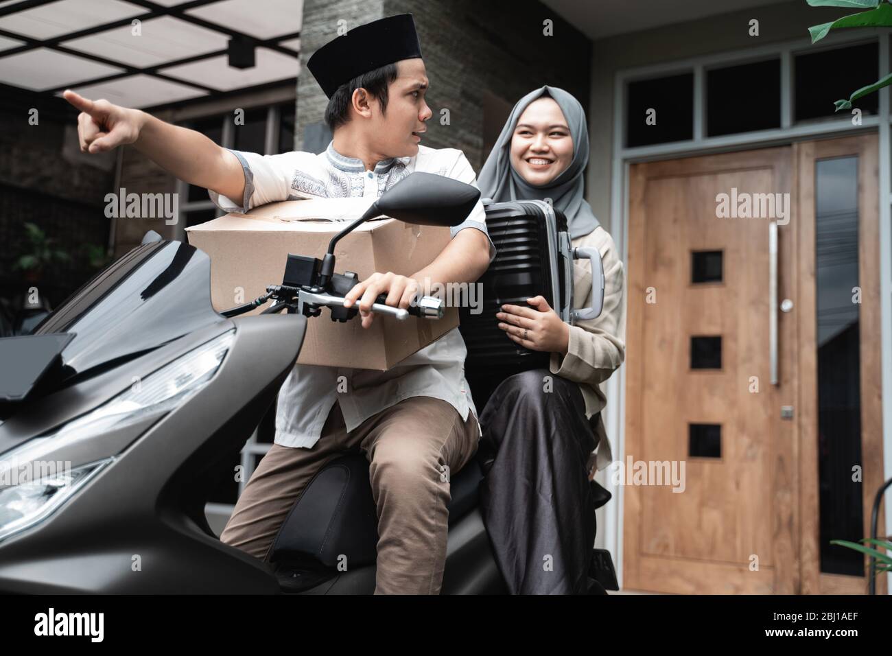 Muslim couple riding a motorcycle for mudik to home when Eid mubarak ...