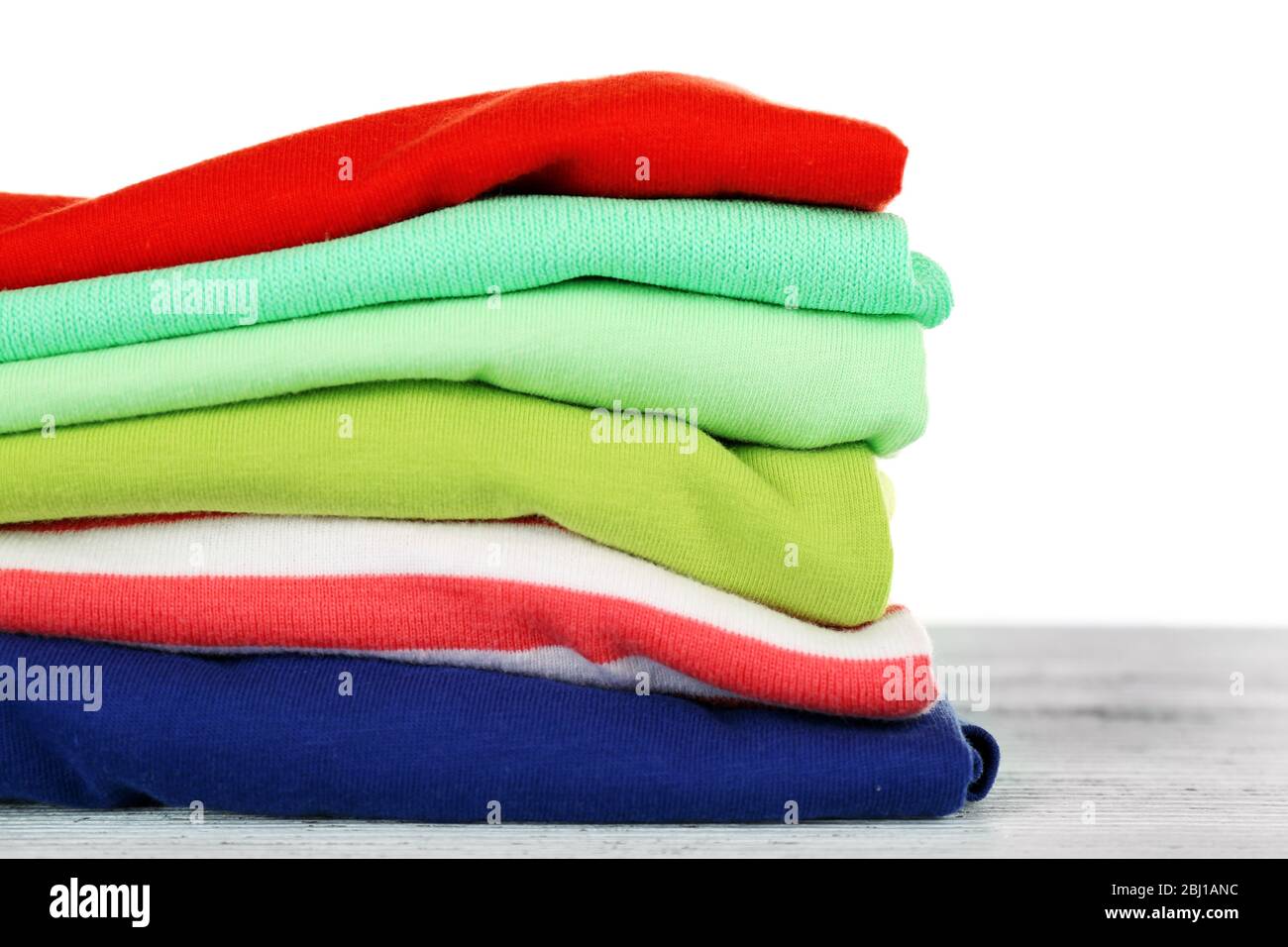 Stack of colorful clothing isolated on white Stock Photo - Alamy