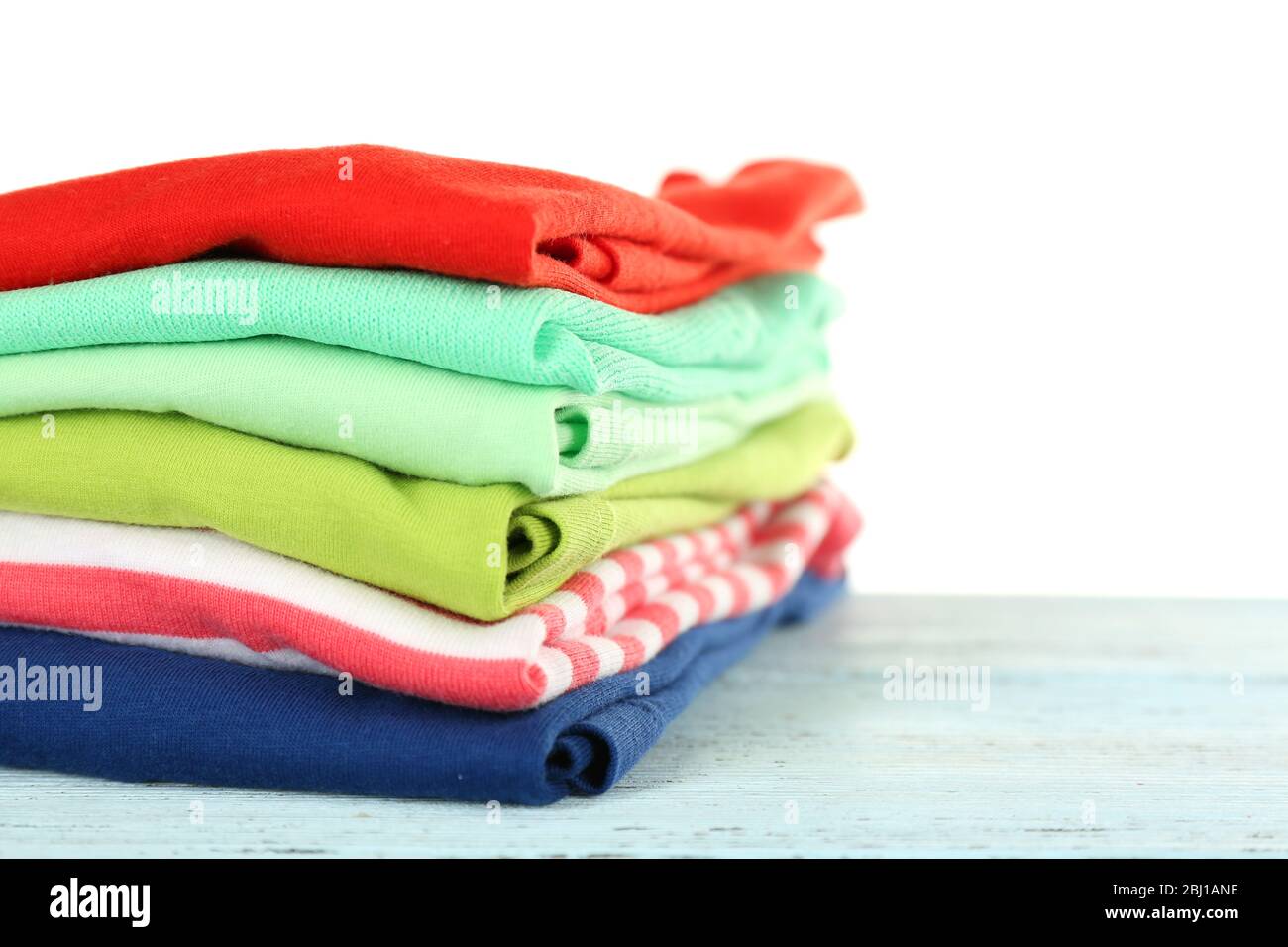 Stack of colorful clothing isolated on white Stock Photo - Alamy