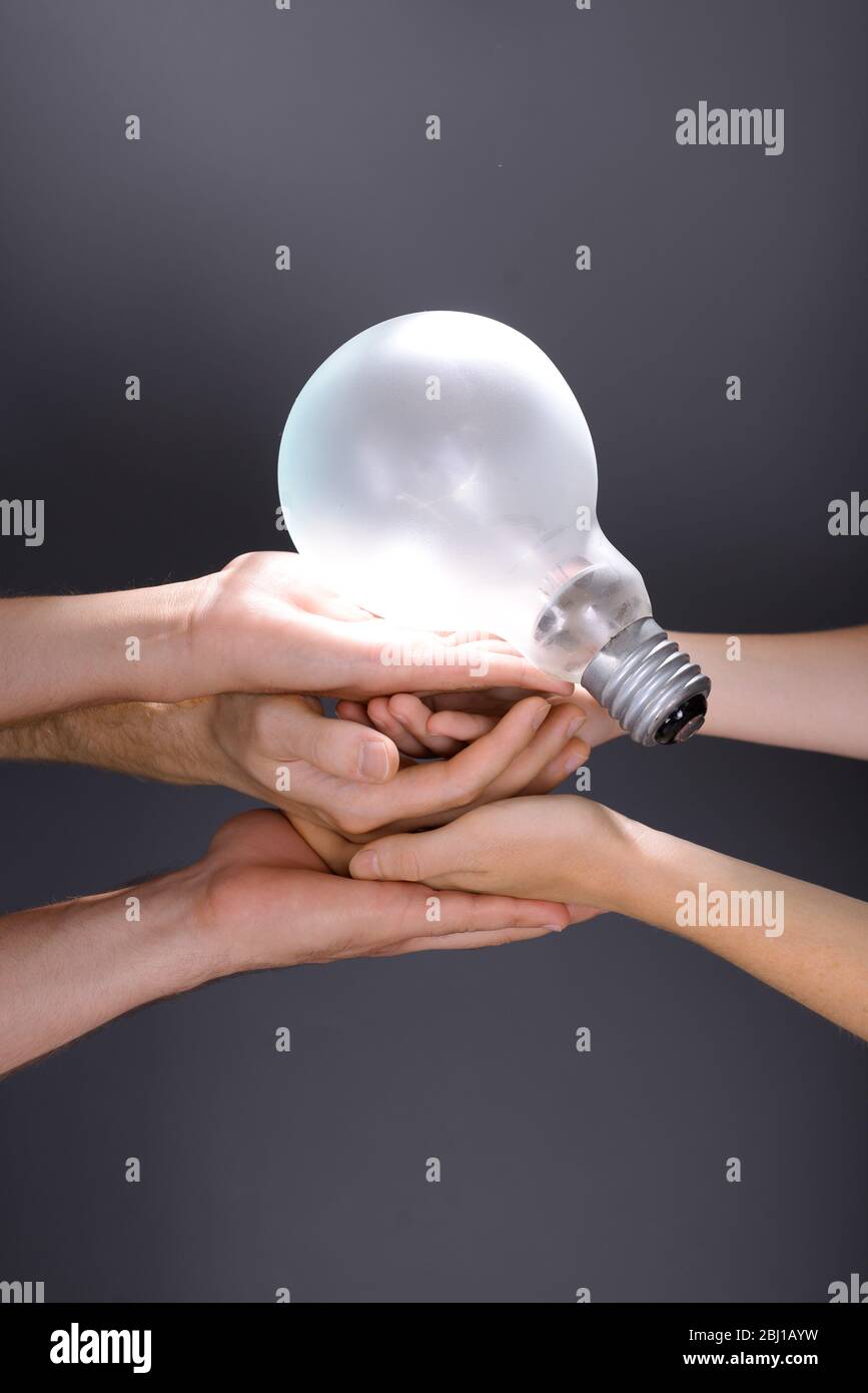 Light bulb in hands on grey background Stock Photo - Alamy