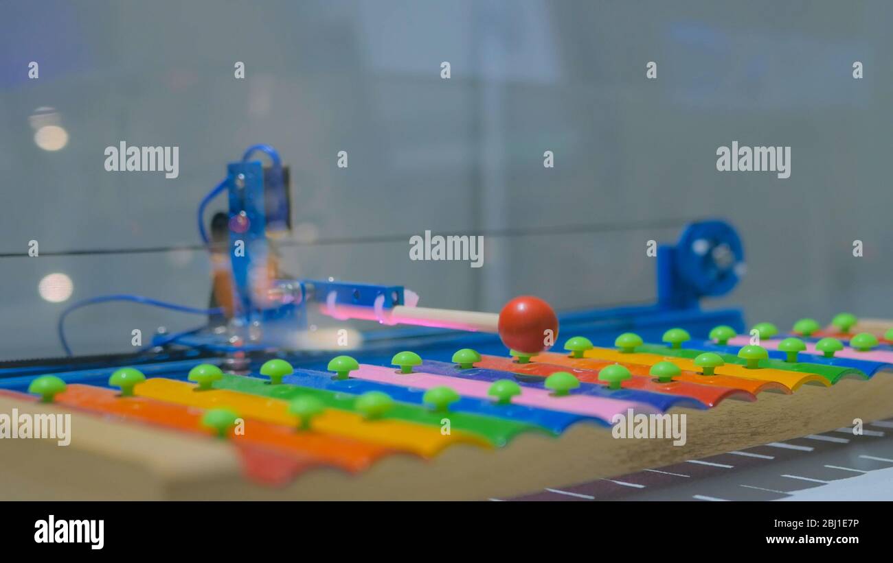 Robot playing on colorful xylophone at technology exhibition. Future ...