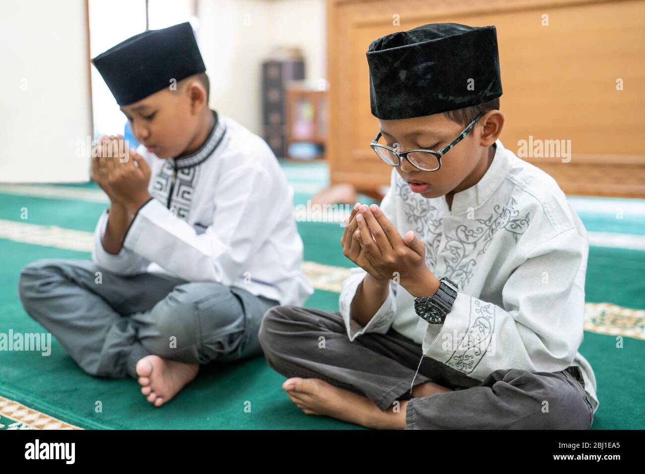 Two children praying hi-res stock photography and images - Alamy