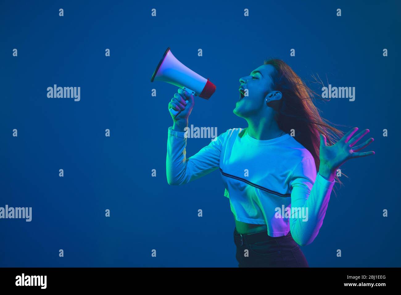 Shouting with speaker. Caucasian young woman's portrait isolated on ...