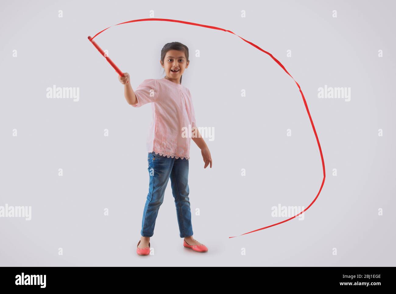 young girl playing with a ribbon wand Stock Photo - Alamy