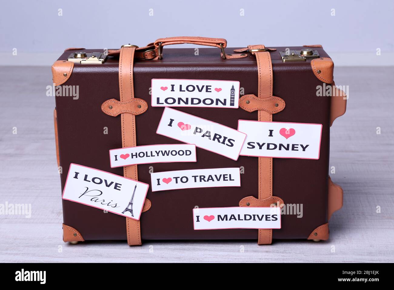 Suitcase with stickers on floor in room Stock Photo - Alamy