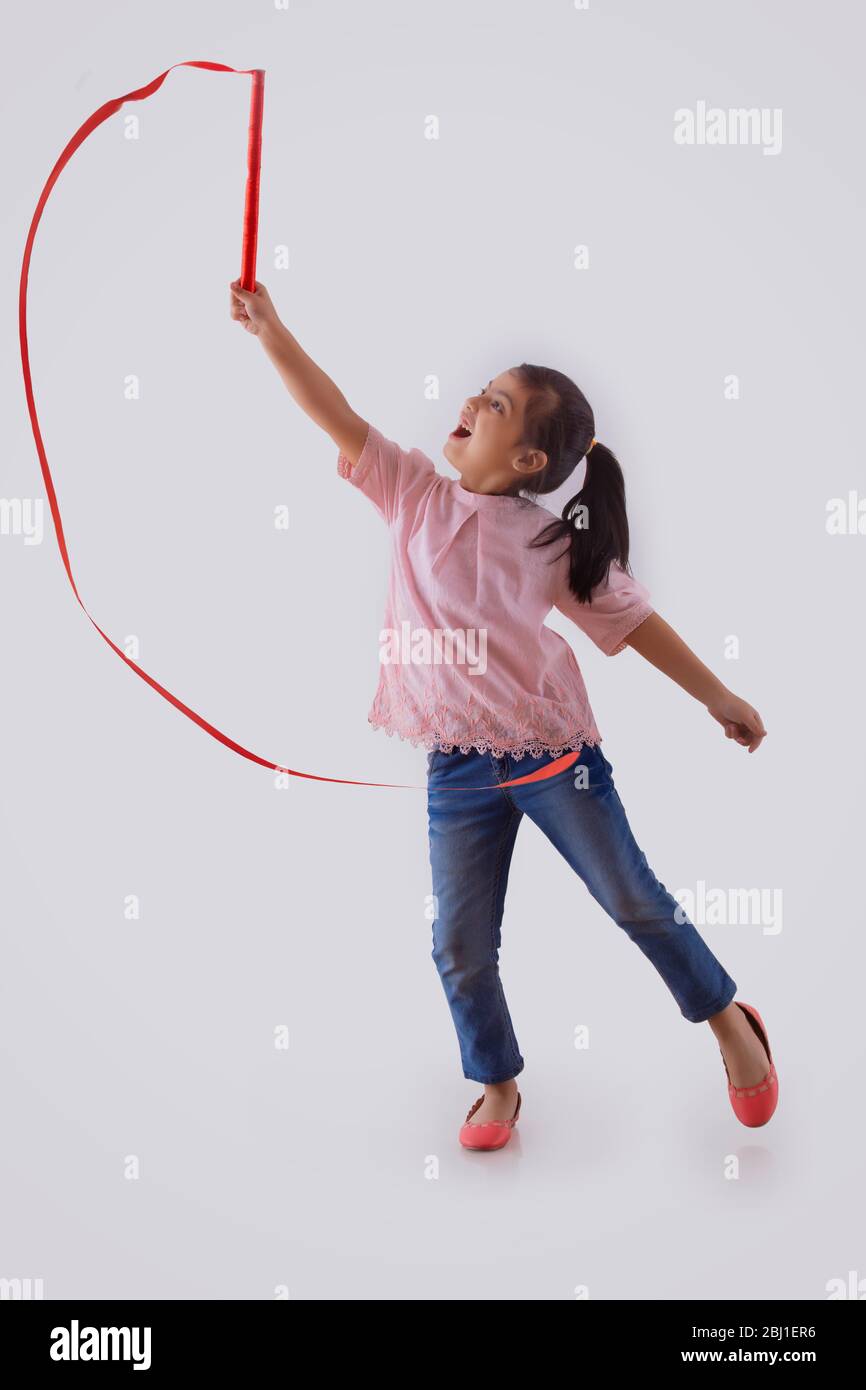young girl playing with a ribbon wand Stock Photo - Alamy