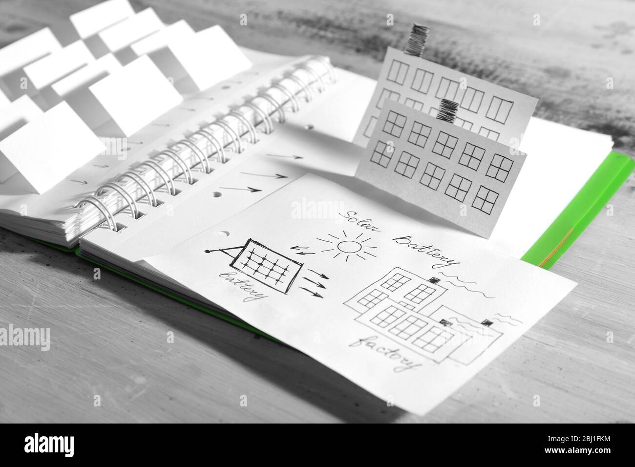Handmade model of solar panels in notebook on wooden table, closeup ...