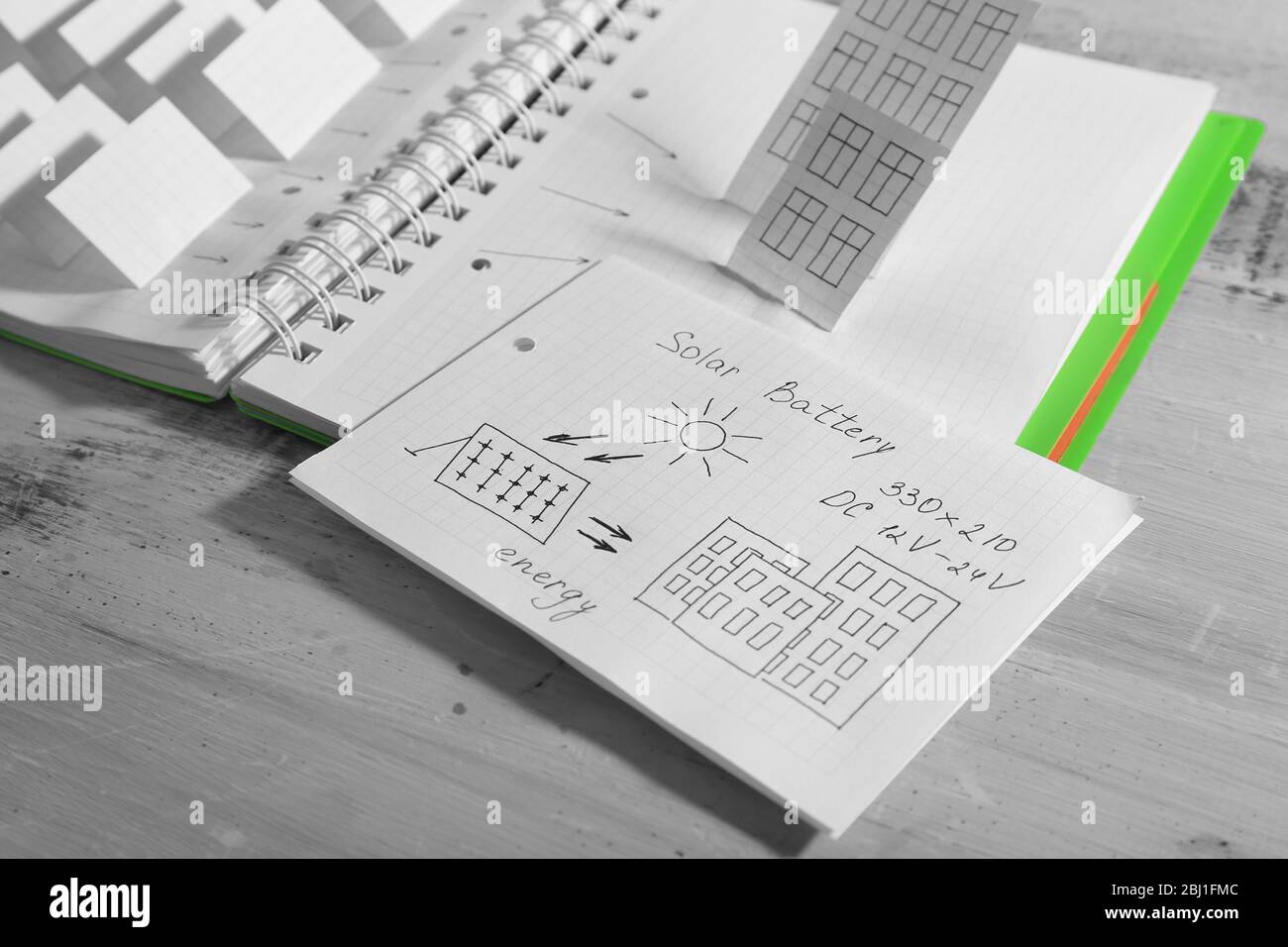 Handmade model of solar panels in notebook on wooden table, closeup ...