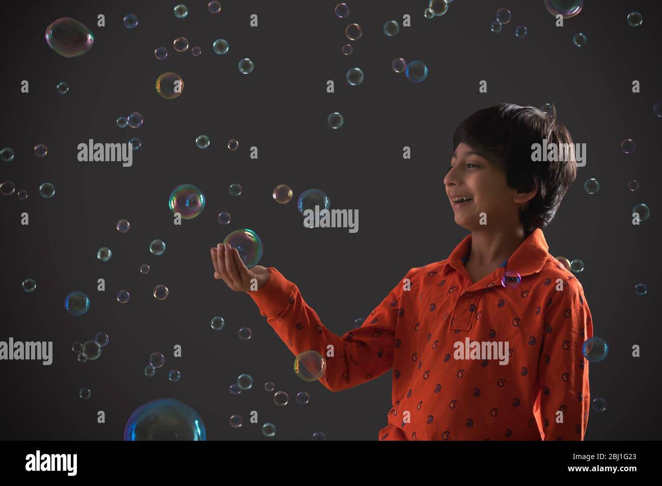 portrait of a young boy holding a bubble in her hand Stock Photo - Alamy