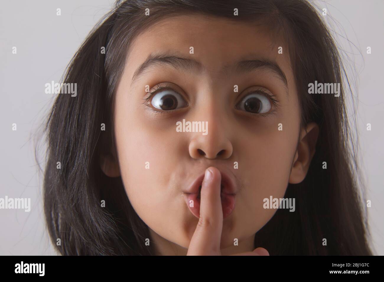 close up of a young girl with finger on her lips Stock Photo - Alamy