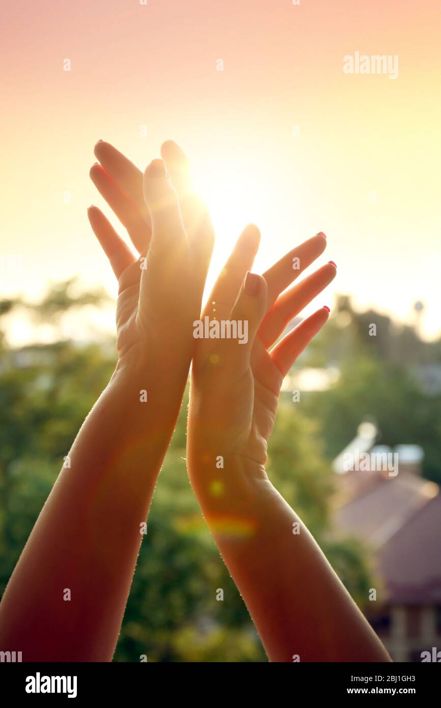 Female hands over sunset sky background Stock Photo - Alamy