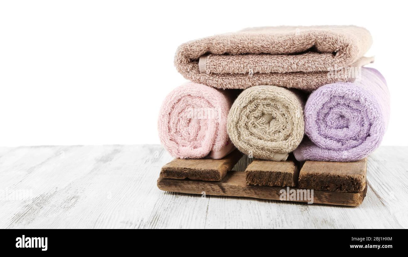 Rolled bath towels on wooden table, closeup Stock Photo - Alamy