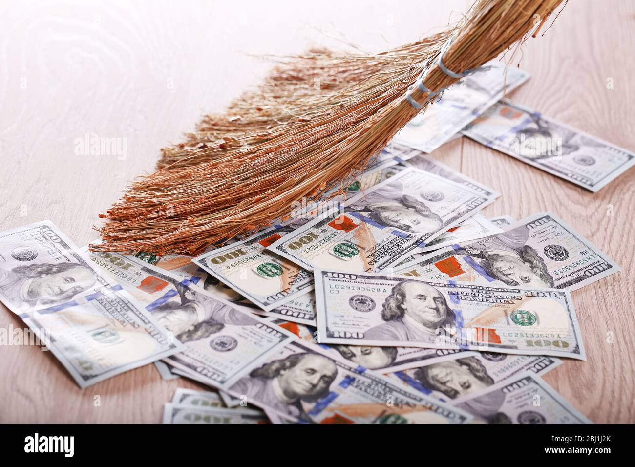 Dollars and broom on wooden floor, closeup Stock Photo - Alamy