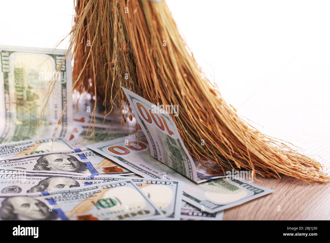 Dollars and broom on wooden floor, closeup Stock Photo - Alamy