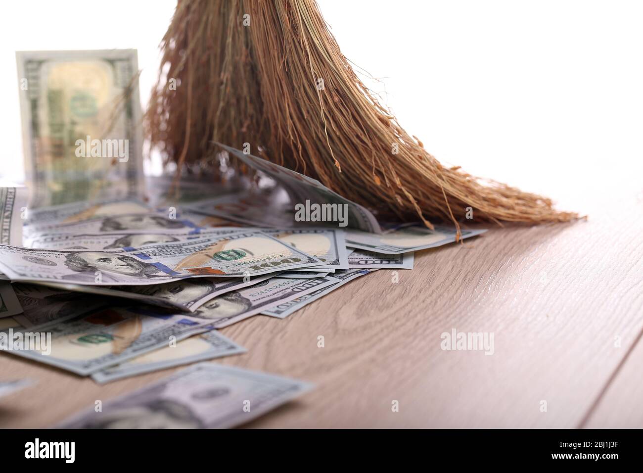 Dollars and broom on wooden floor, closeup Stock Photo - Alamy