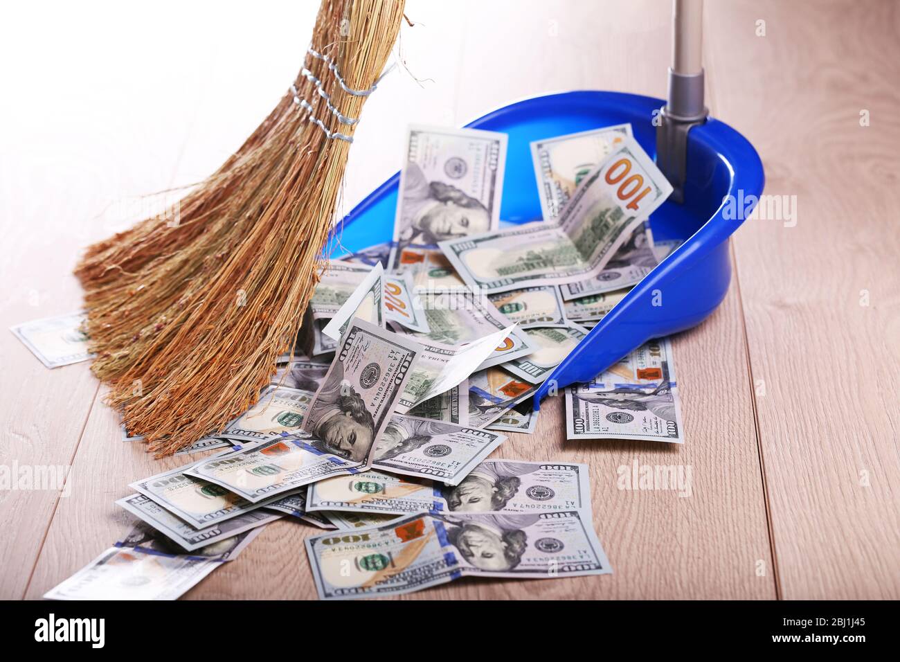 Broom sweeping dollars in scoop from on wooden floor, closeup Stock ...