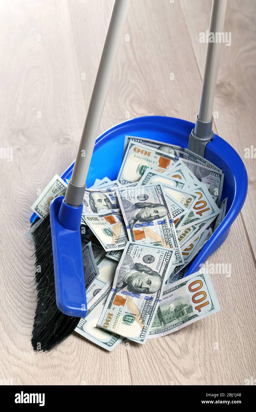 Broom sweeping dollars in scoop from on wooden floor, closeup Stock ...