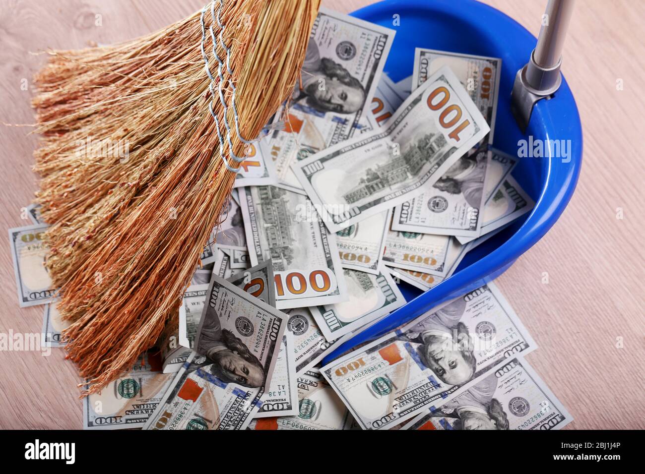 Broom sweeping dollars in scoop from on wooden floor, closeup Stock ...