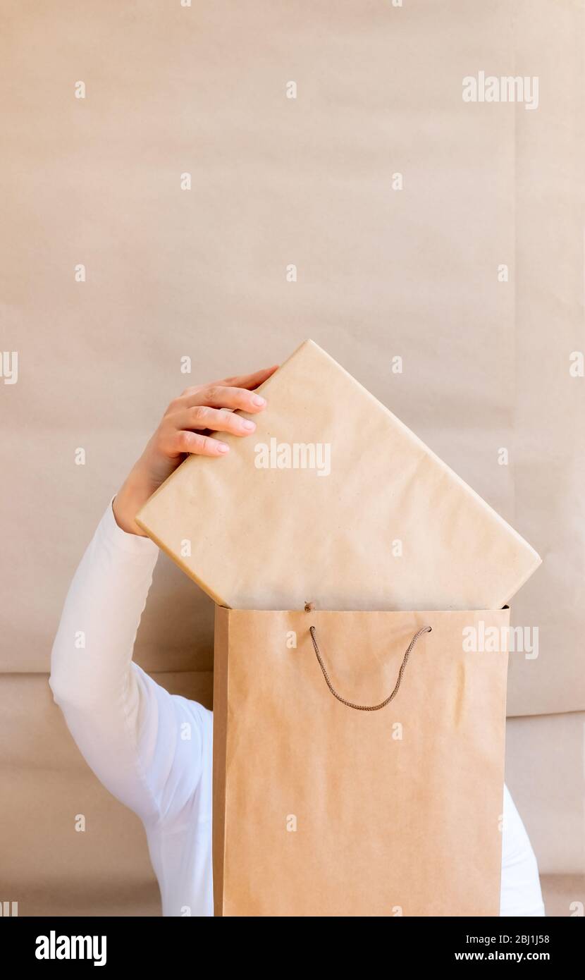 Packer's hands holding a Craft Paper Bag and Box. Worker dressed in ...