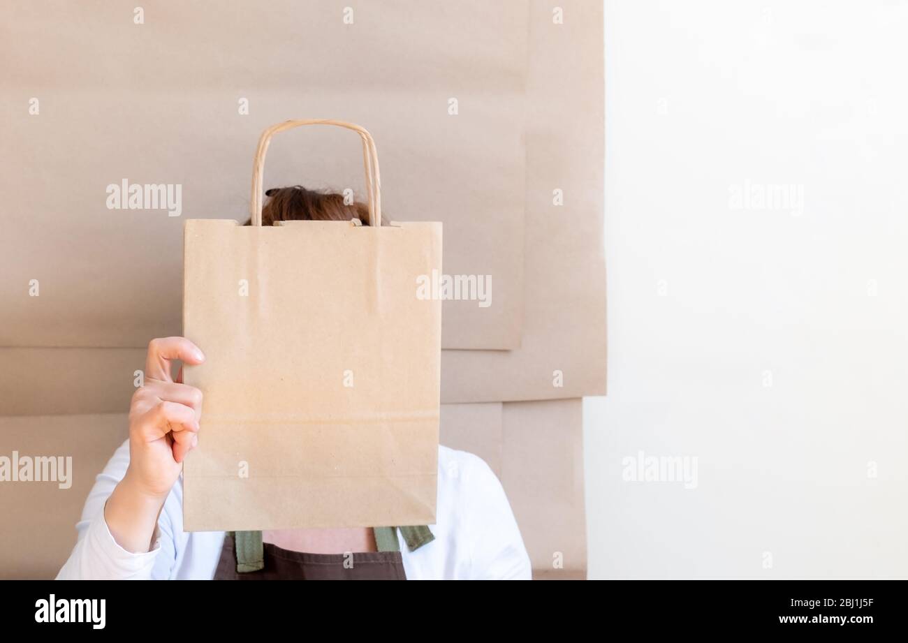 Packer's hands holding a Craft Paper Bag and Box. Worker dressed in ...