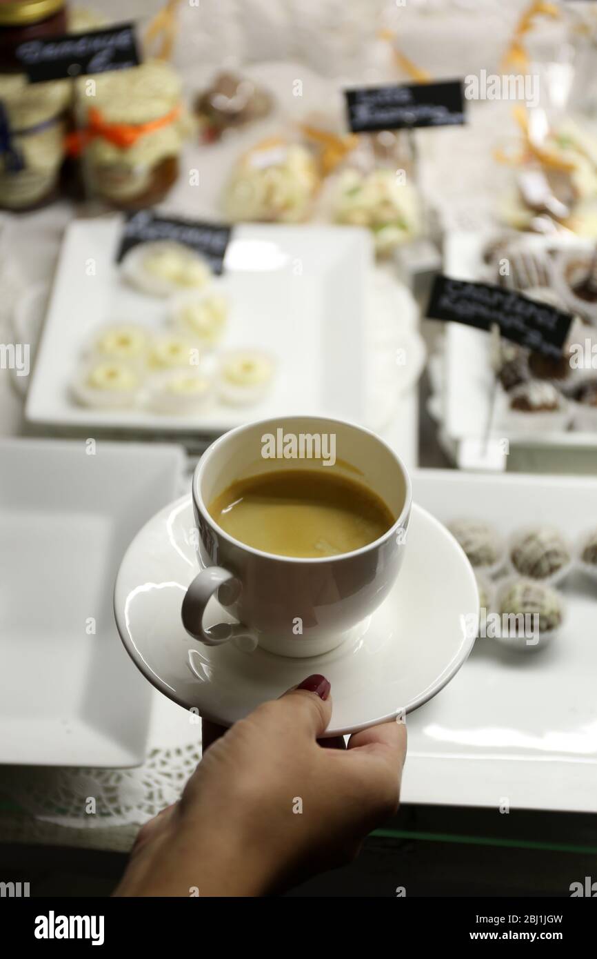 Female hand holding cup of coffee on table background Stock Photo - Alamy